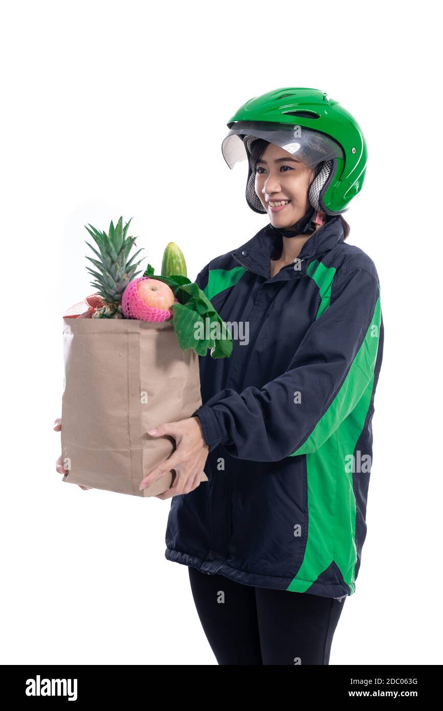 female uber delivery courier wearing helmet bring groceries in the bag ...