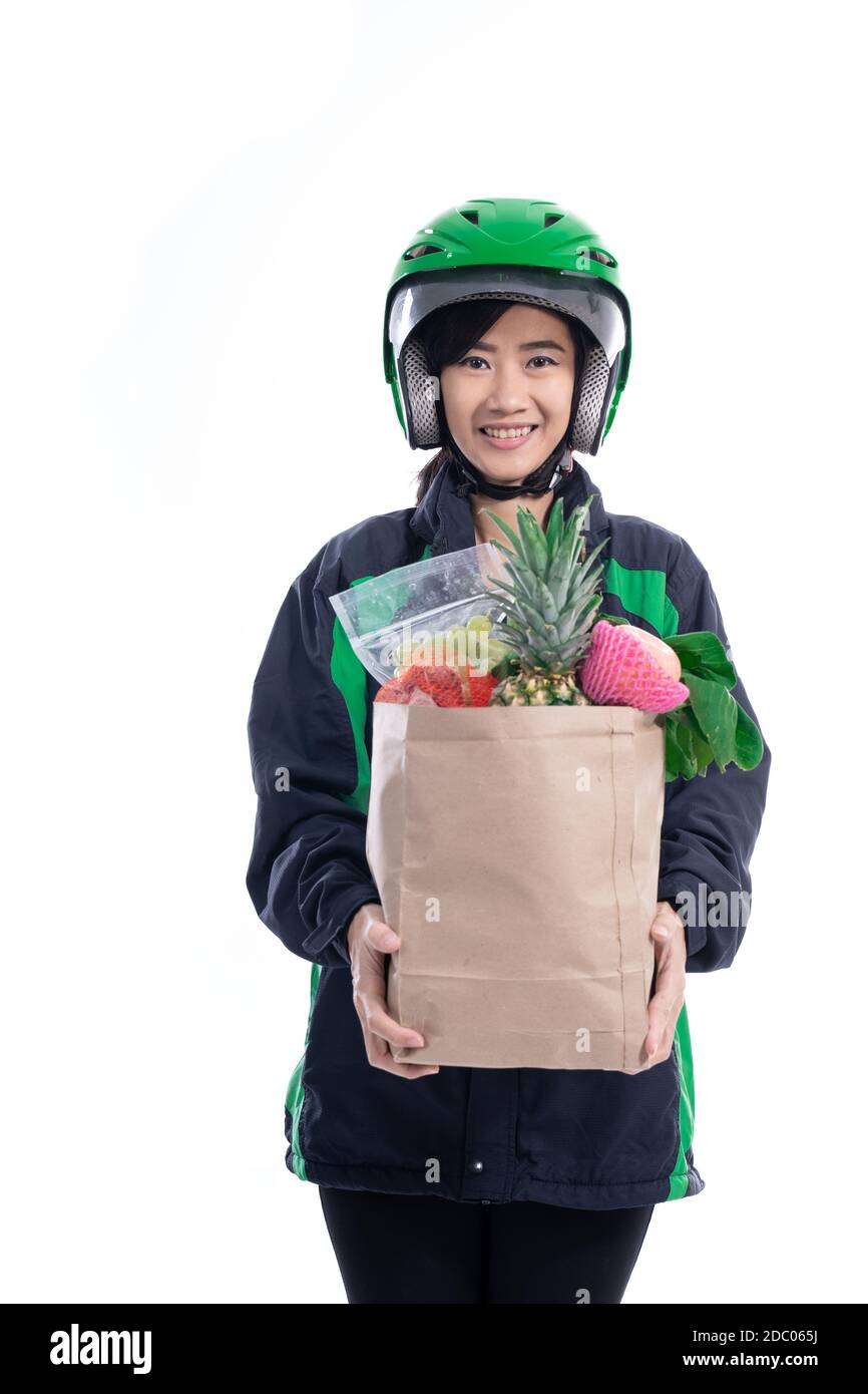 female uber delivery courier wearing helmet bring groceries in the bag ...