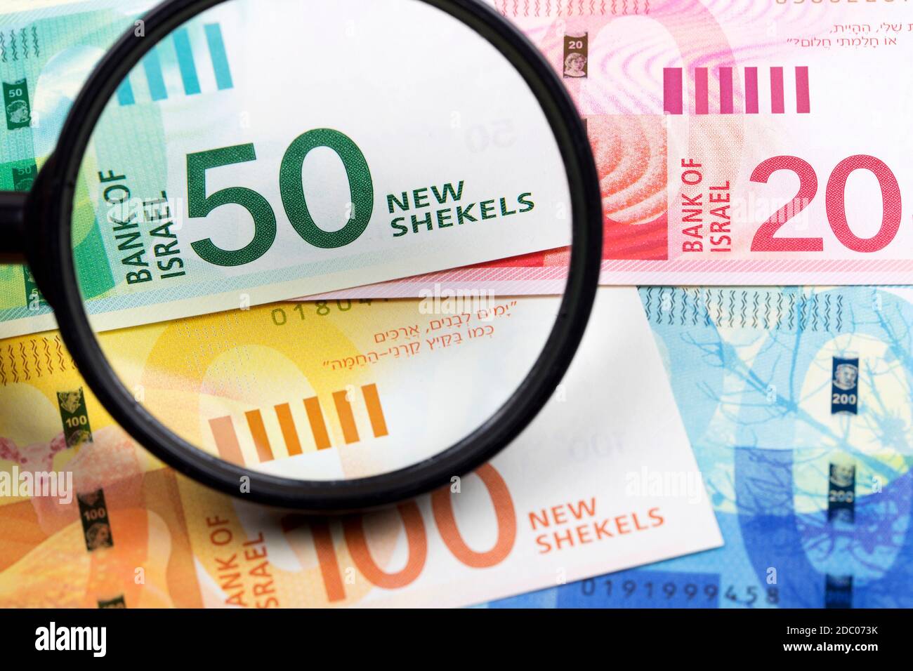 Israeli new shekels in a magnifying glass Stock Photo - Alamy