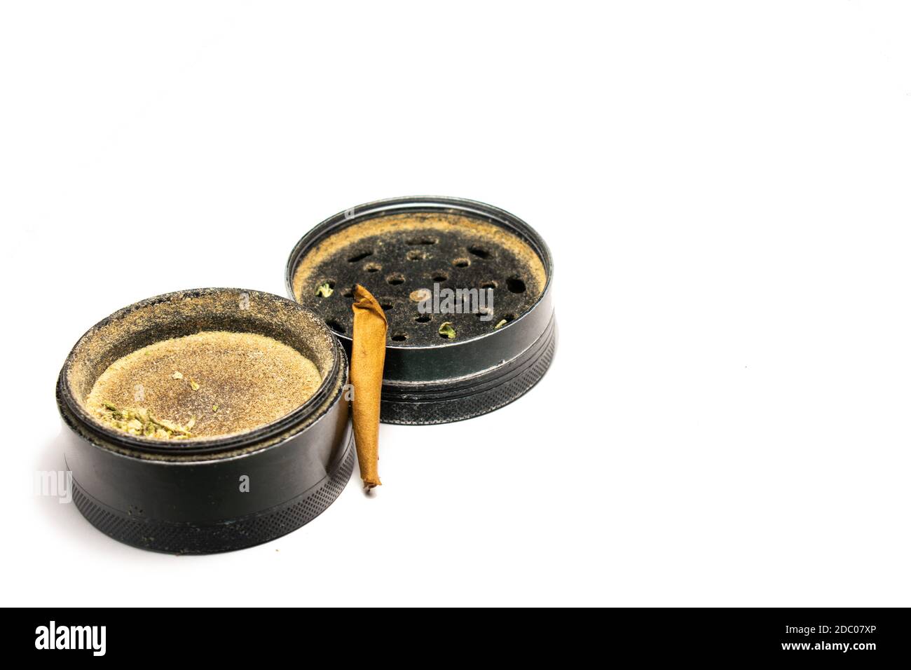 A Black Cannabis Grinder With the Lid Leaning On the Side With the End ...