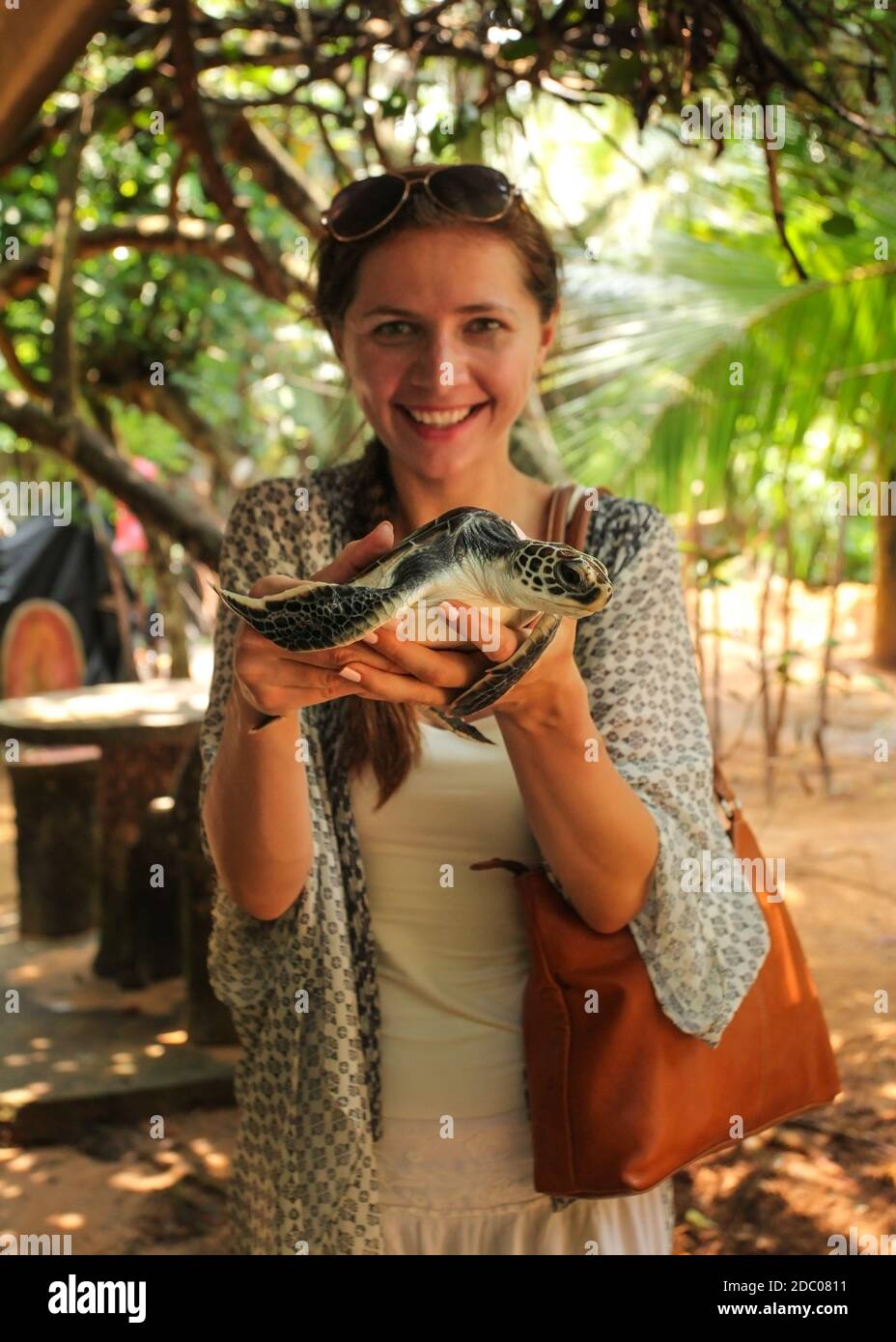 Young woman holding turtle in her hands. Sea Turtle Hatchery Centre ...