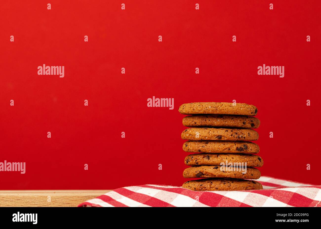 Chocolate chip cookies in stack on red background Stock Photo - Alamy