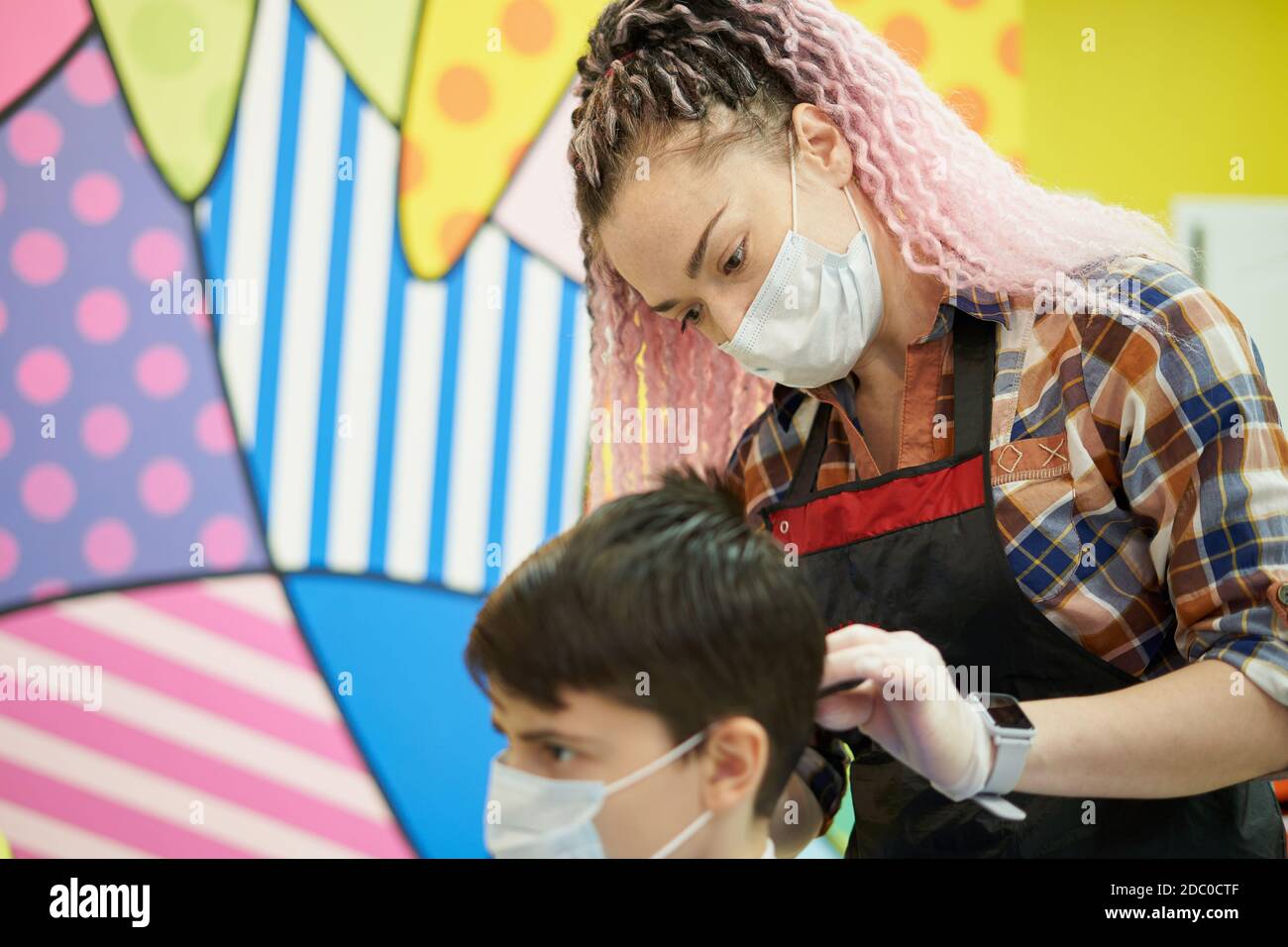 Woman hairdresser in face mask makes haircut to teenager in mask Stock ...