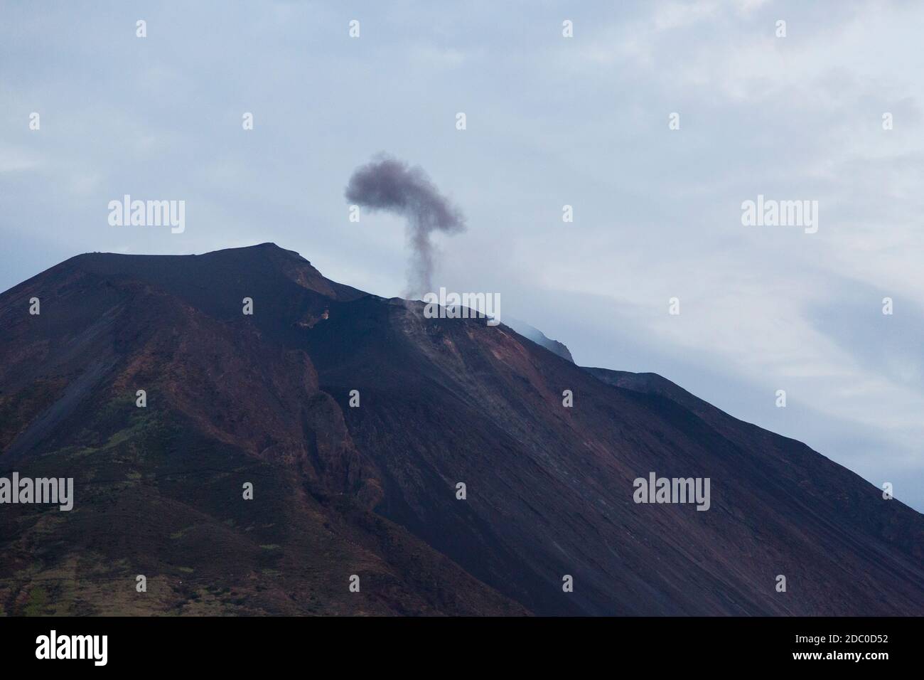 Sicily, Italy. A dark plume of volcanic smoke and ash rises from the ...