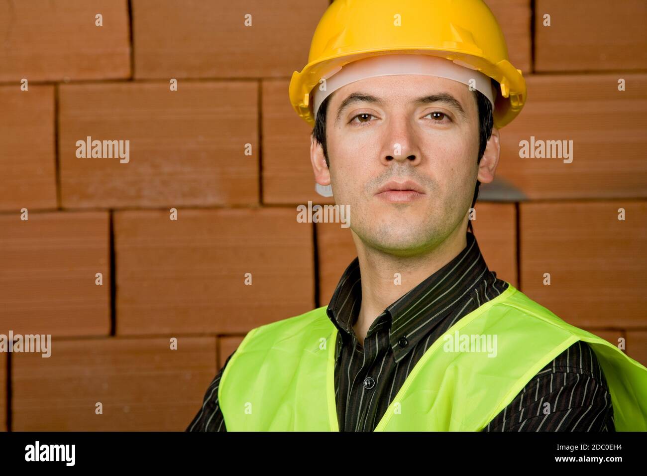 engineer with yellow hat with a brick wall as background Stock Photo ...