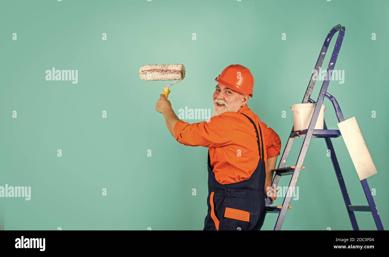 painter in overall and cap with paint bucket. builder worker painting ...