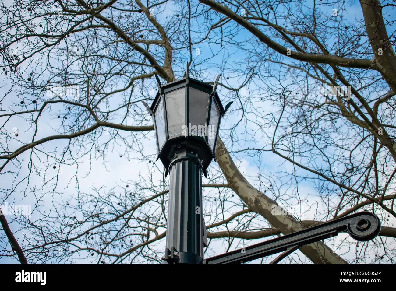 An Old Fashioned Black Metal Lamp Post on a Clear Blue Sky In Suburban ...