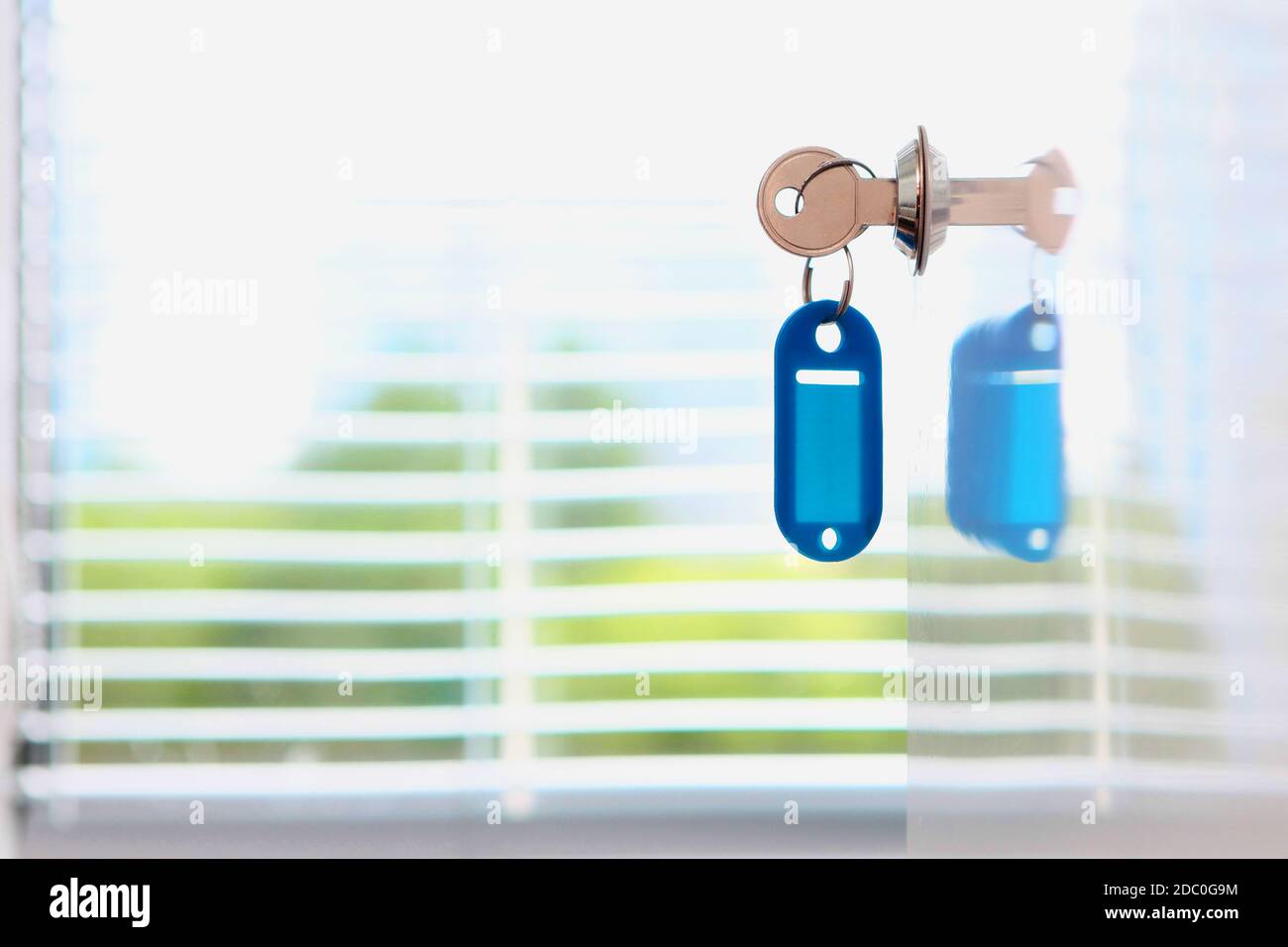 Key with a key ring in the keyhole against the background of a window ...