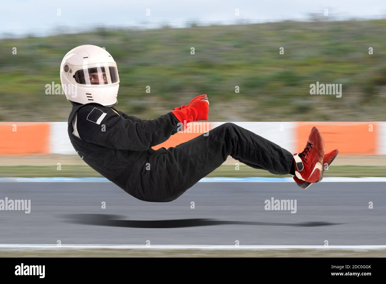 Racing driver in racing position with complete gear isolated in white ...