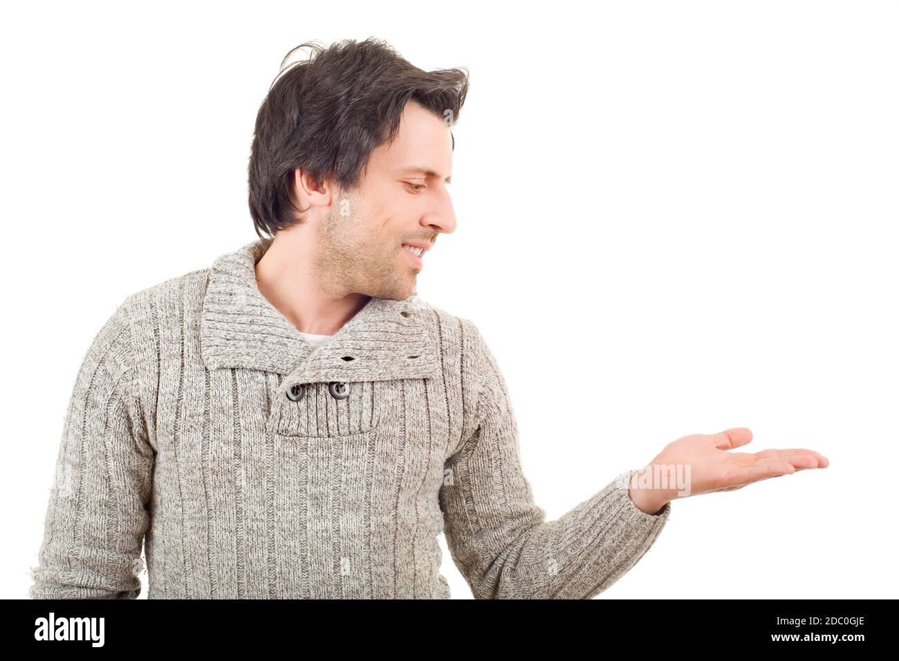 friendly young man pointing to his side and looking into the camera ...