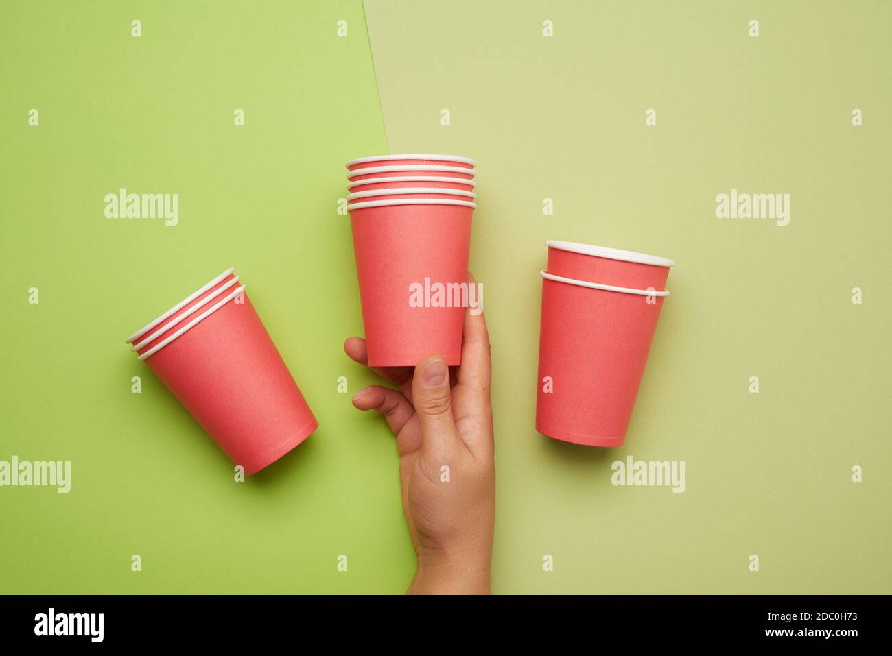 stack of red paper disposable cups on a green background, concept eco ...
