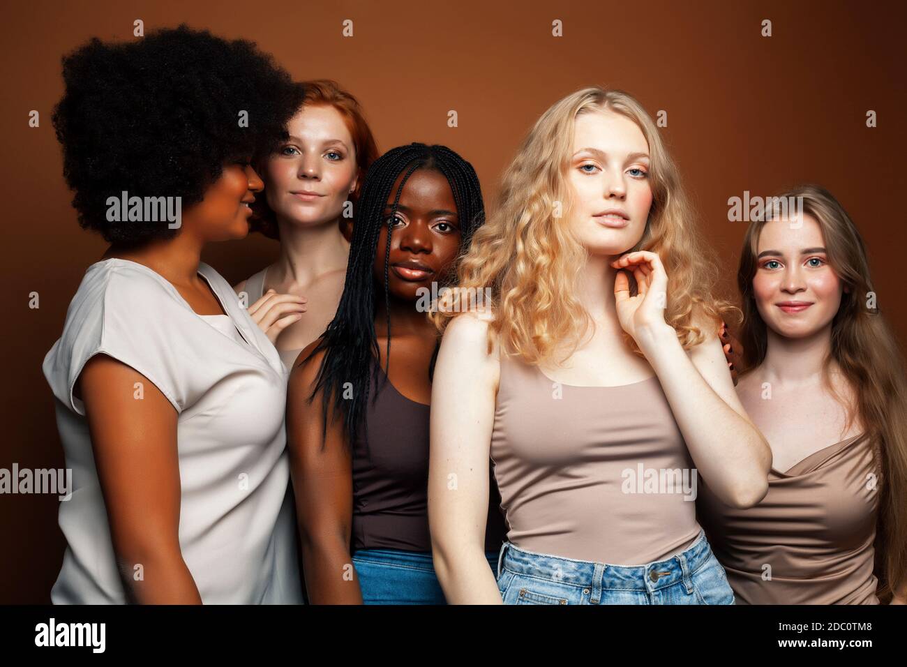 young pretty caucasian, afro, scandinavian woman posing cheerful together on brown background ...