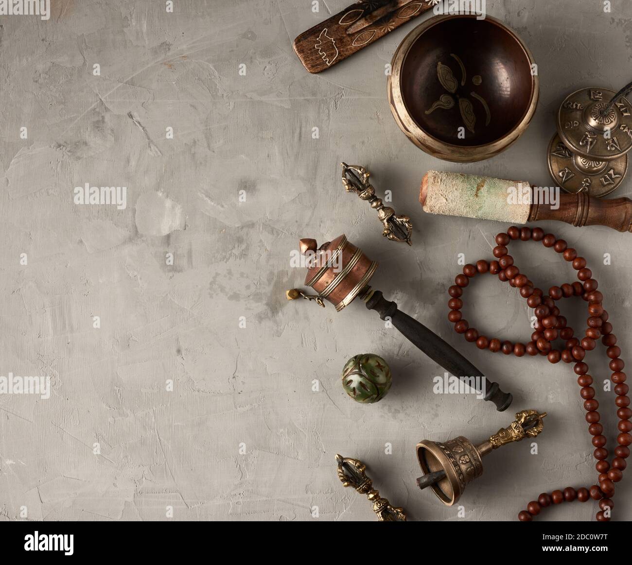 Tibetan singing copper bowl with a wooden clapper on a gray cement ...