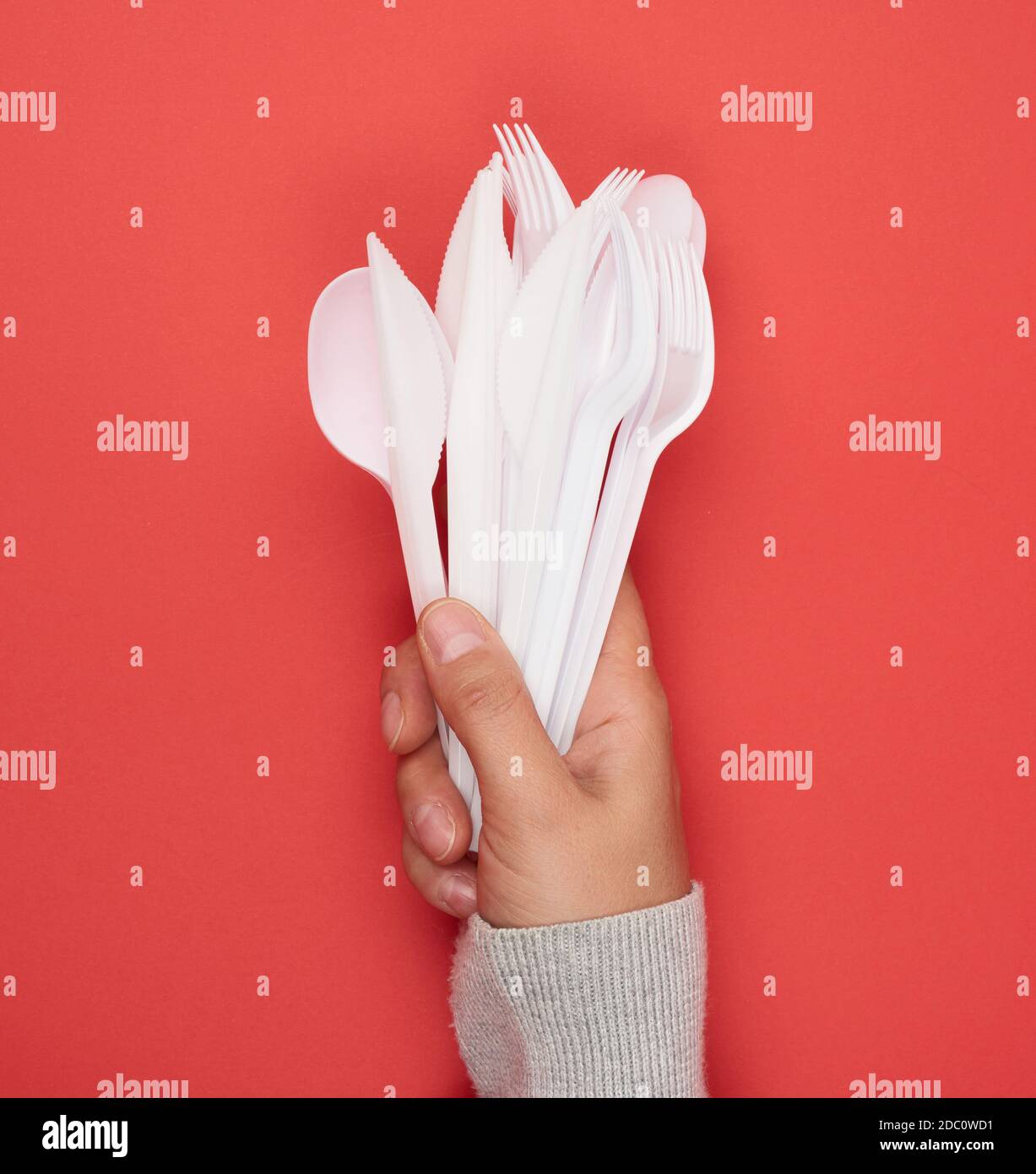 stack of plastic forks and spoons on red background, close up Stock ...