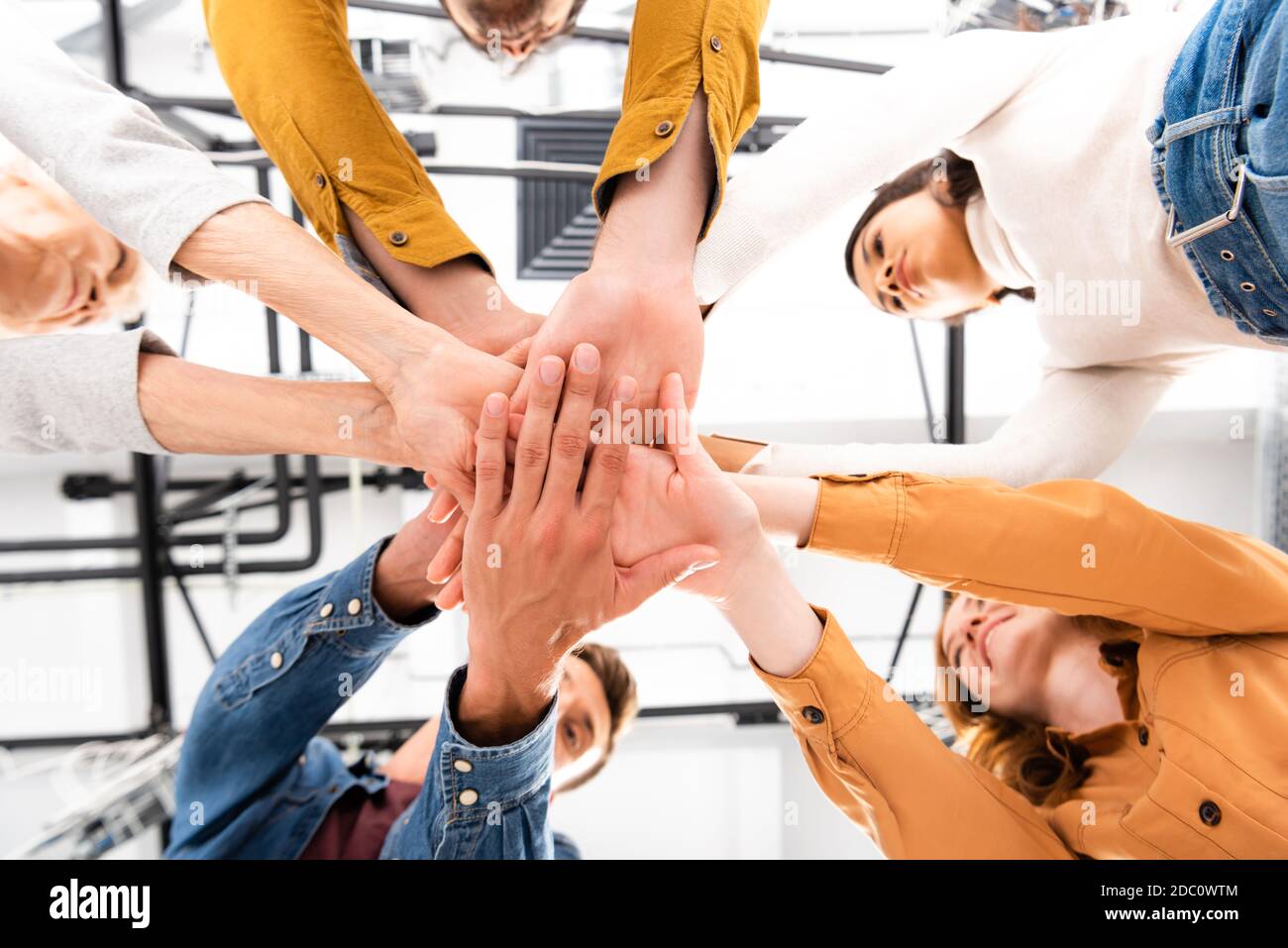 Bottom view of multicultural people holding hands and smiling on ...