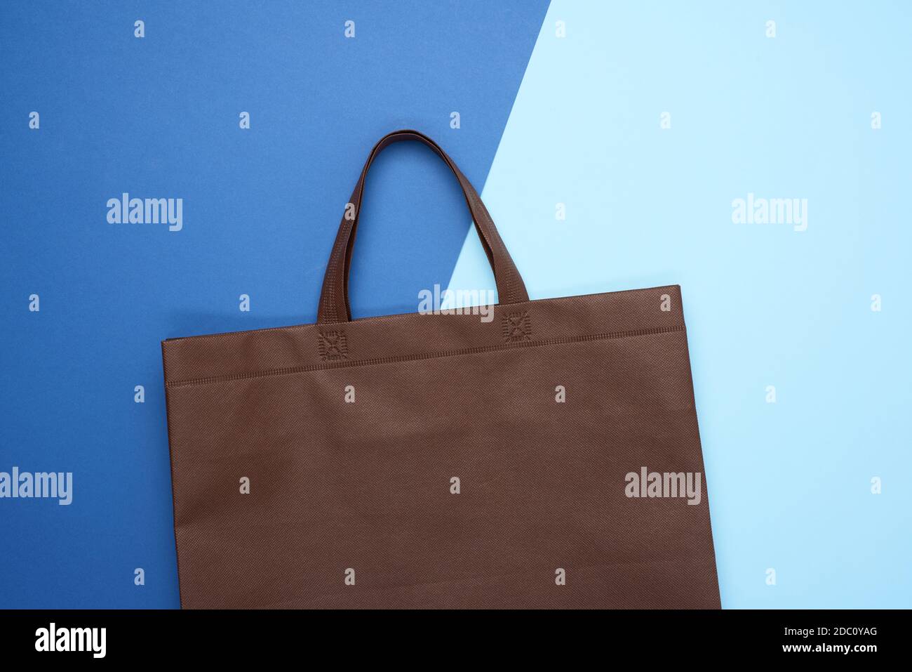 empty brown eco bag on blue background, rejection of plastic bags, flat ...
