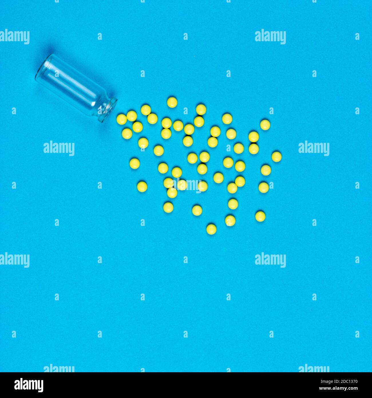 Pharmaceutical yellow pills, pills and empty jar on a blue background ...