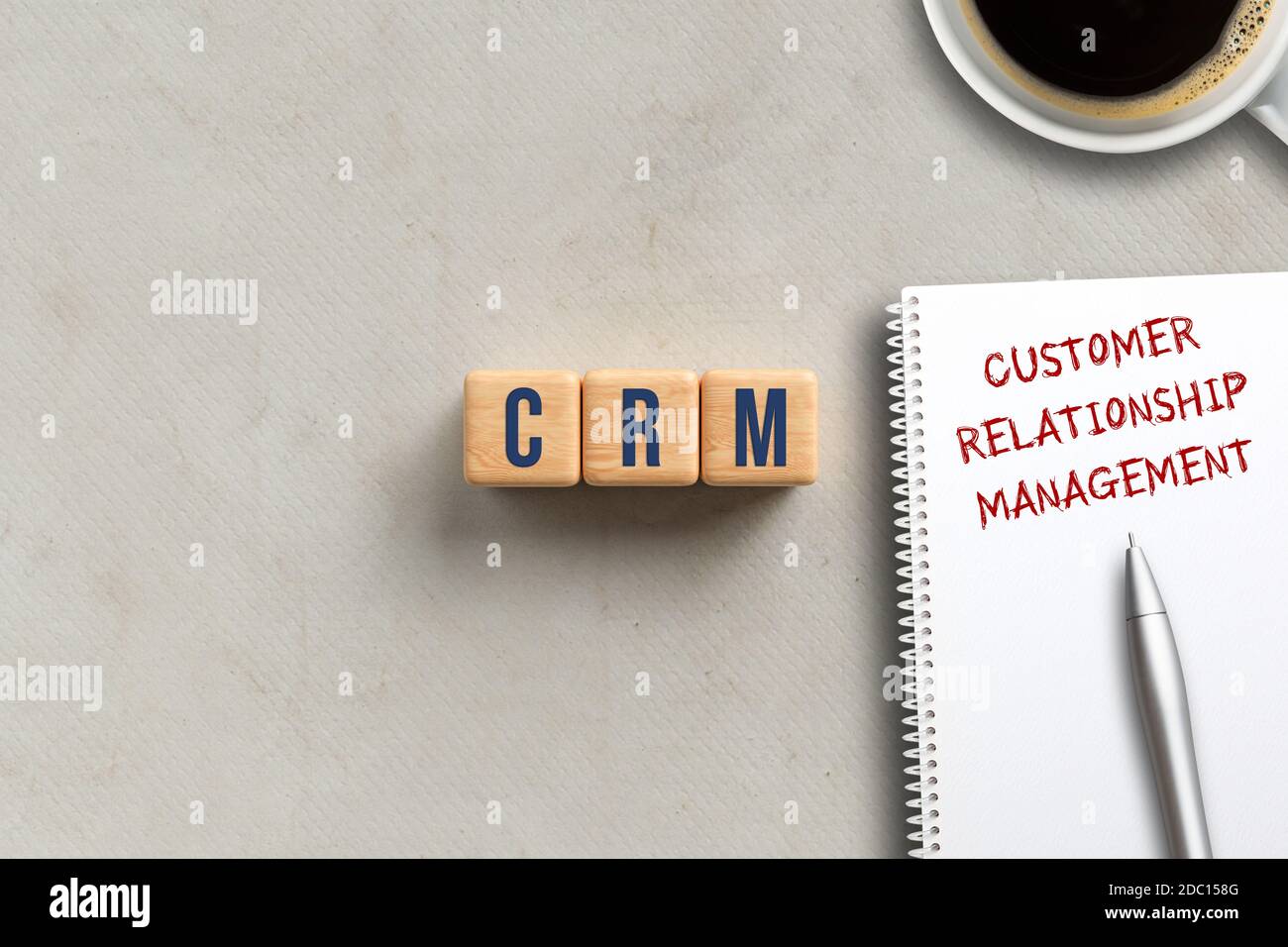 acronym CRM on cubes and notepad with explanation CUSTOMER RELATIONSHIP ...