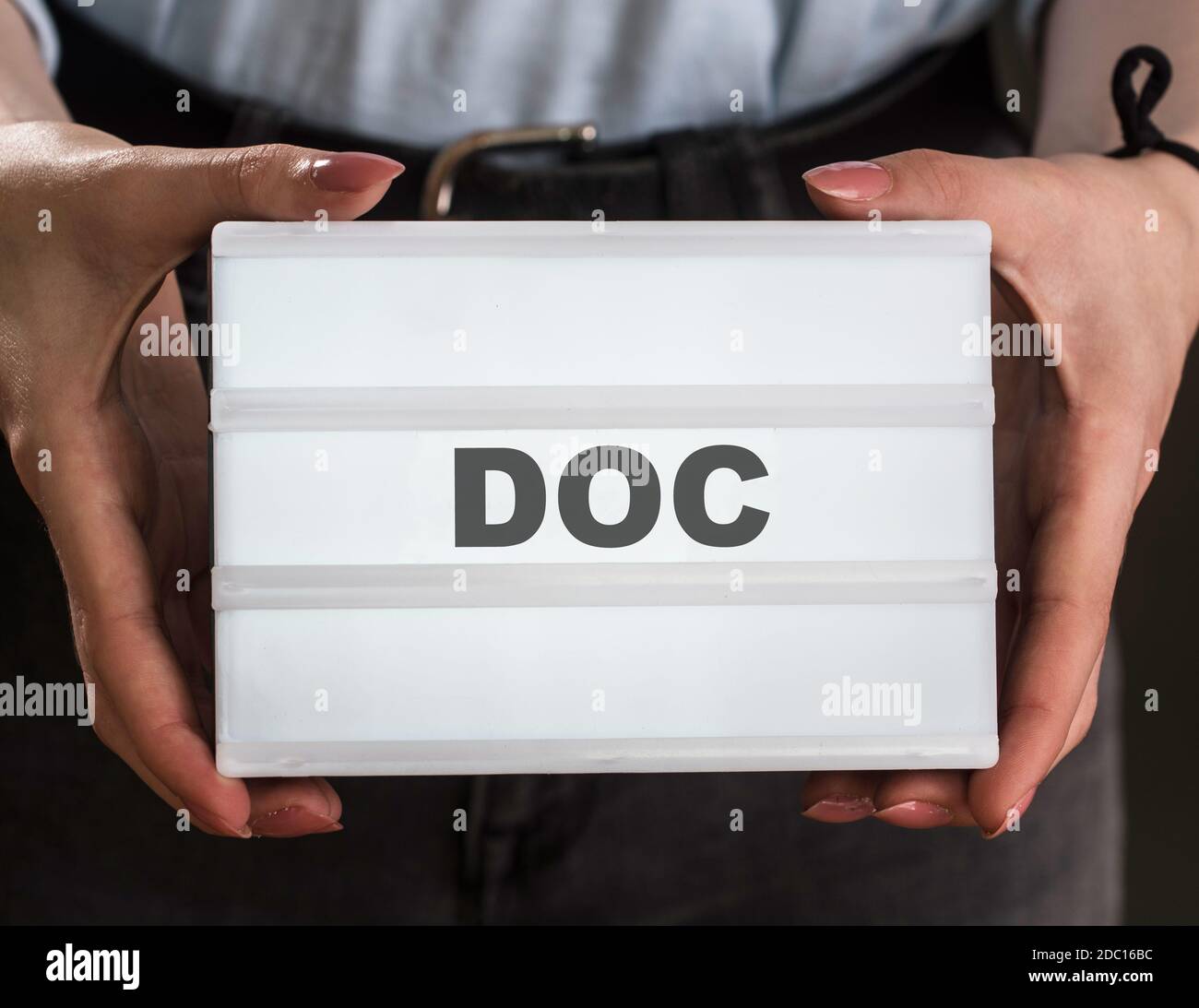 woman holding with both hands a sign that says DOC Stock Photo - Alamy