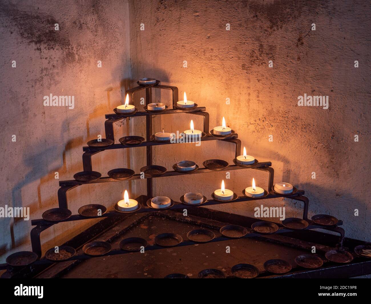 Small Tea lights on a metal stand inside a church Stock Photo - Alamy