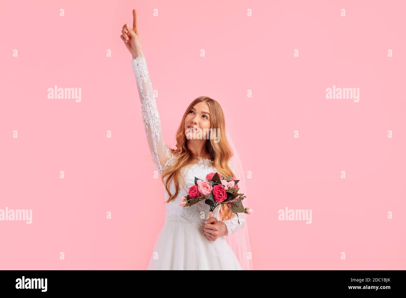 Happy excited bride with a bouquet of flowers in a wedding dress ...