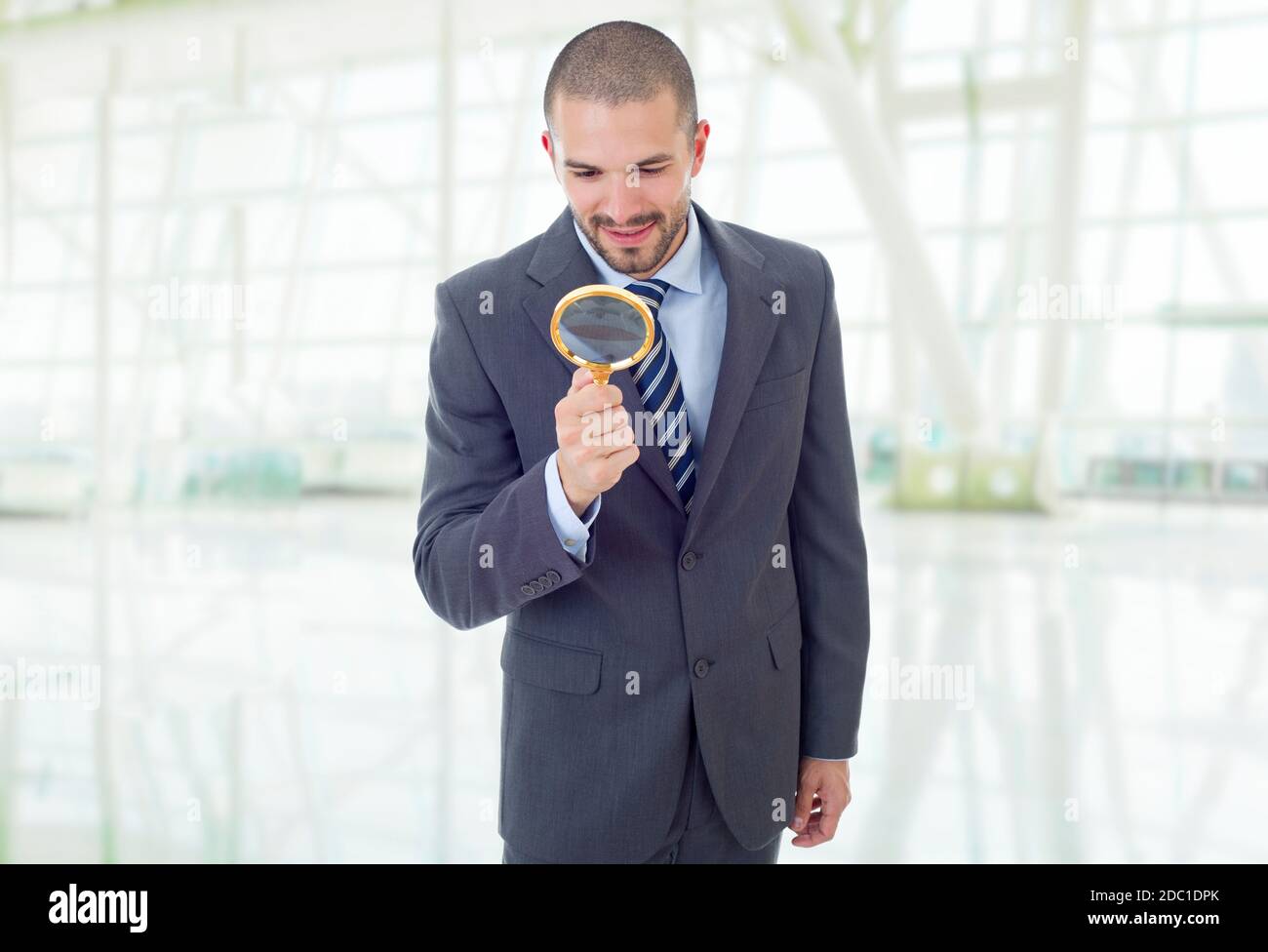 young business man with magnifying glass, at the office Stock Photo - Alamy
