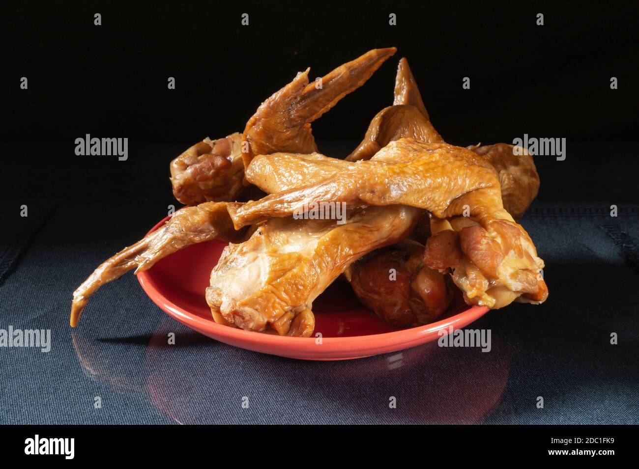 The Smoked wing of the hen in red plate on black background.Roasted ...