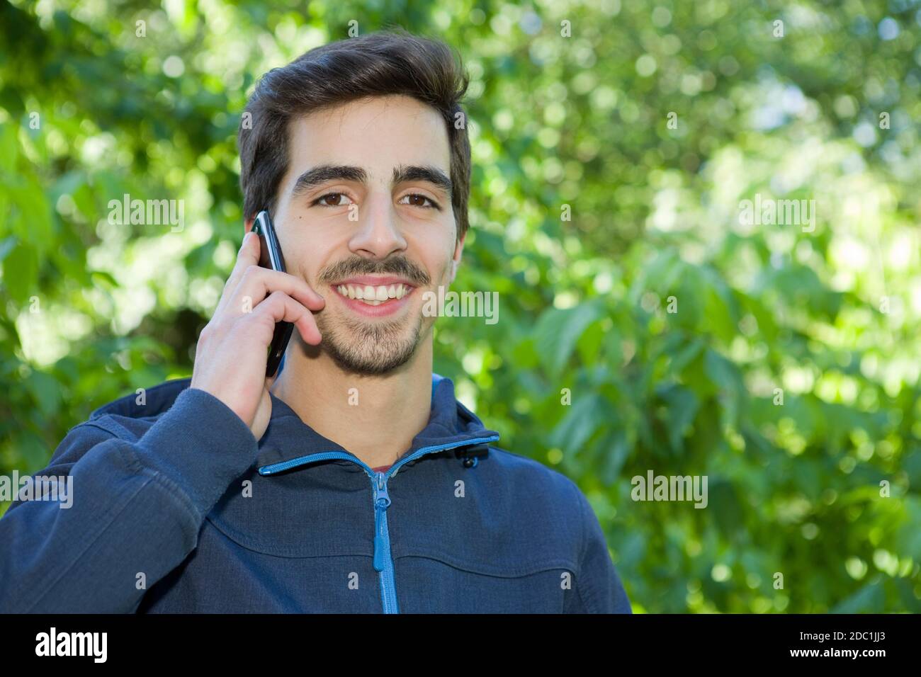 happy young casual man on the phone outdoor Stock Photo - Alamy