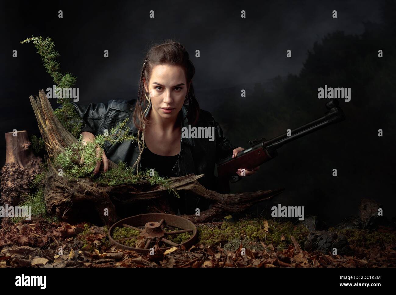 Portrait of a young woman with a rifle. A serious girl in a black ...
