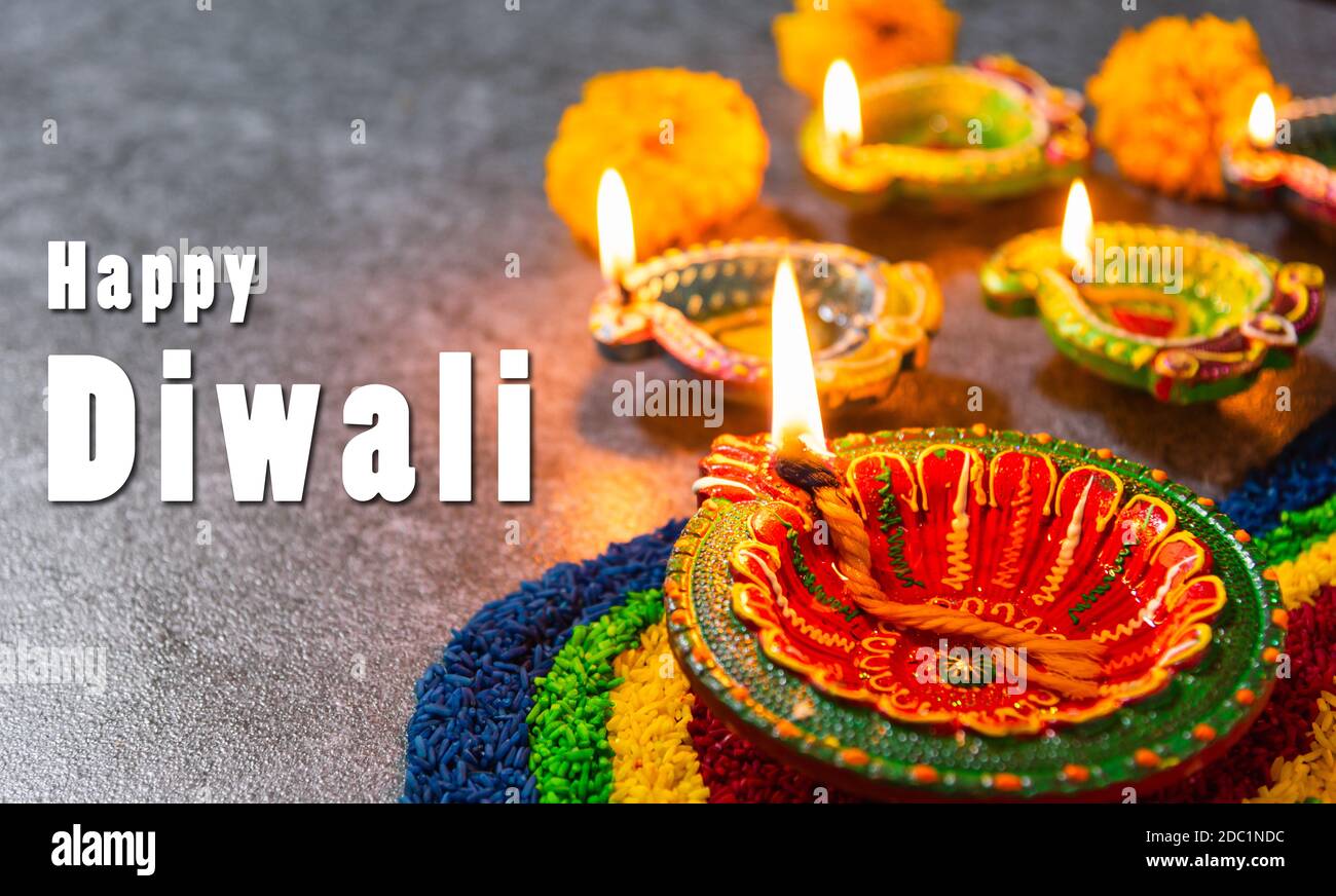 Close up clay lit light a fire already on Diya or oil lamp with flowers ...