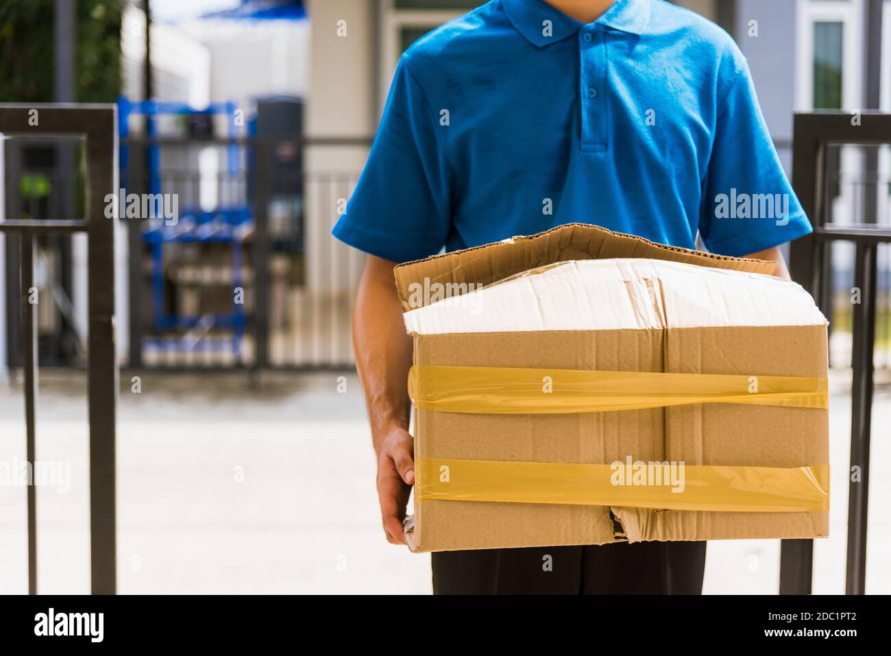 Asian young delivery man in blue uniform he emotional falling courier ...