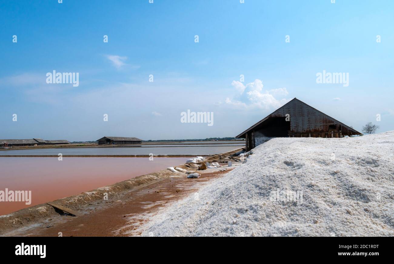 Landscape of brine salt farm with blue sky on sunny day. Salt warehouse ...