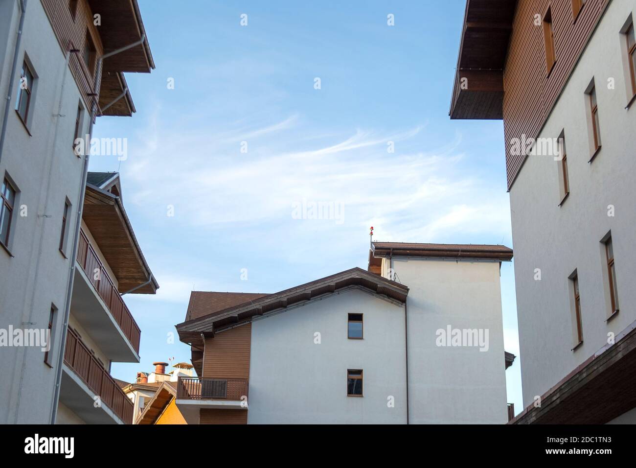 Houses with balconies opposite blue sky - bottom-up view Stock Photo ...