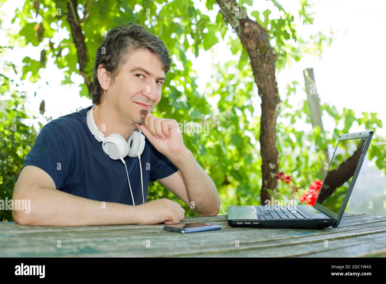 man sitting outdoor working with a laptop Stock Photo - Alamy