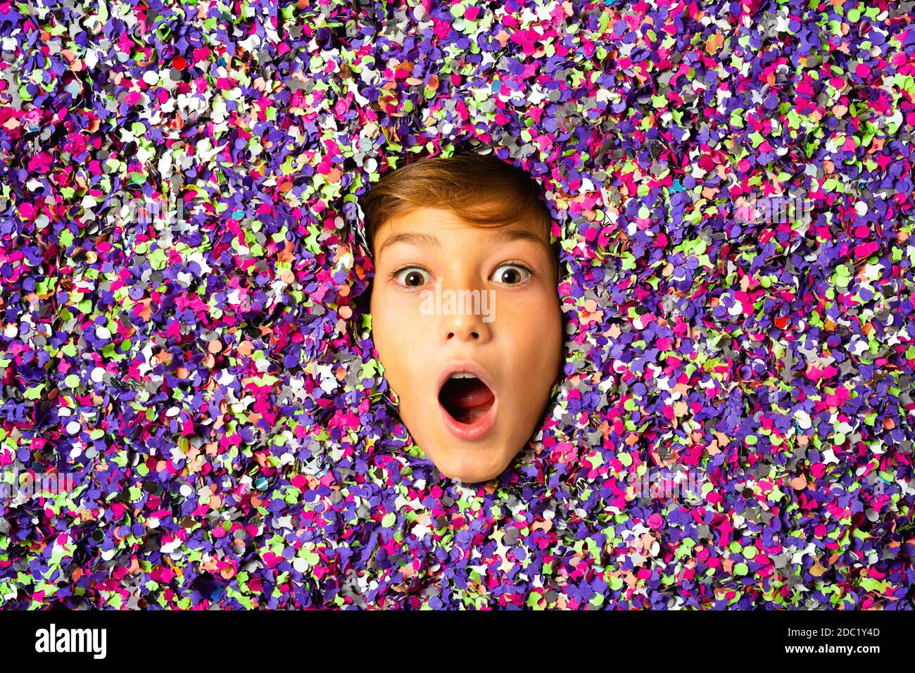 Surprised Young boy face being surrounded by colored confetti Stock ...