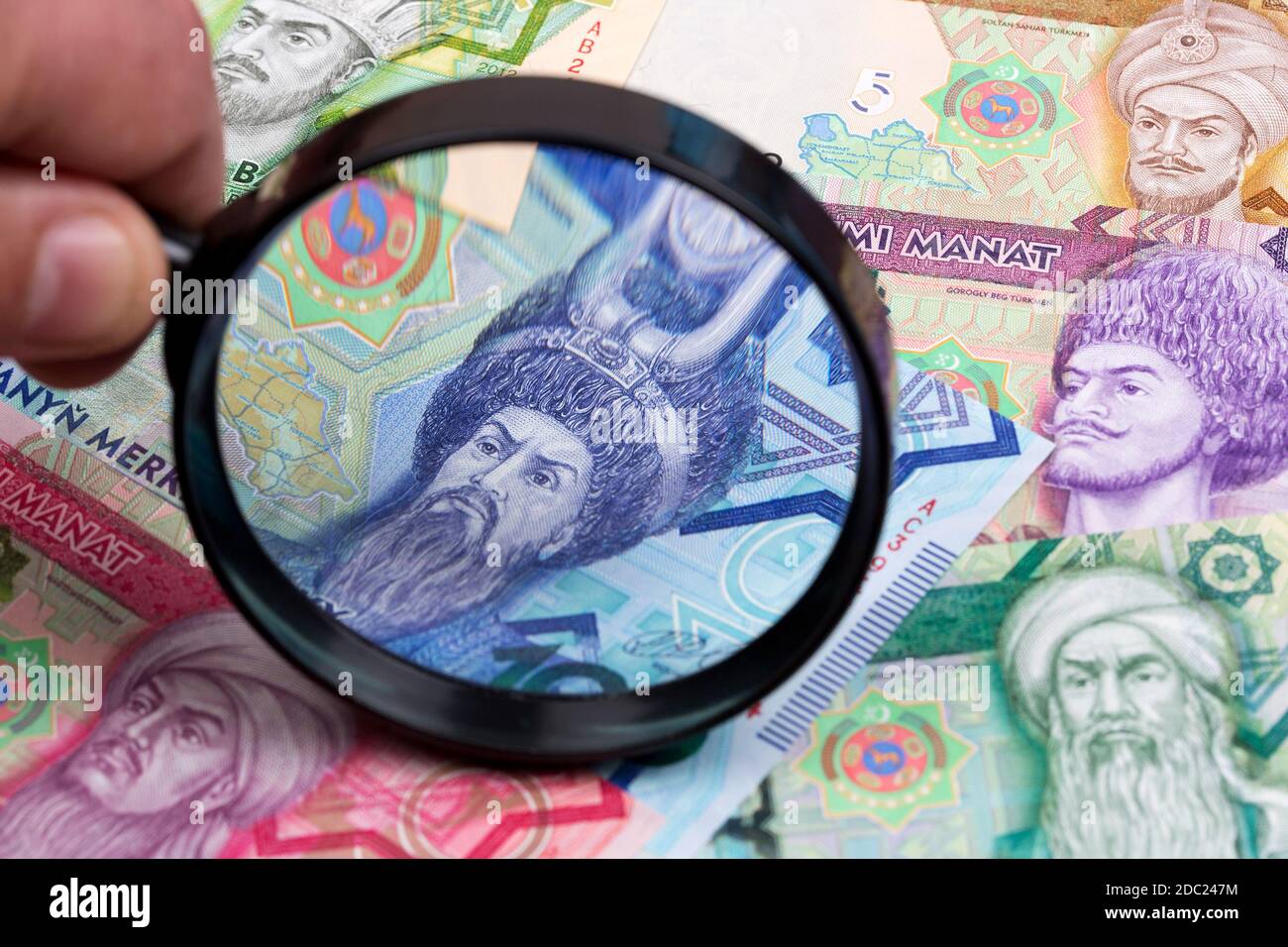Turkmenistan manat in a magnifying glass Stock Photo - Alamy