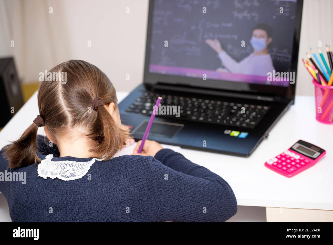Distance learning-online education. School girl watching online education classes and doing ...