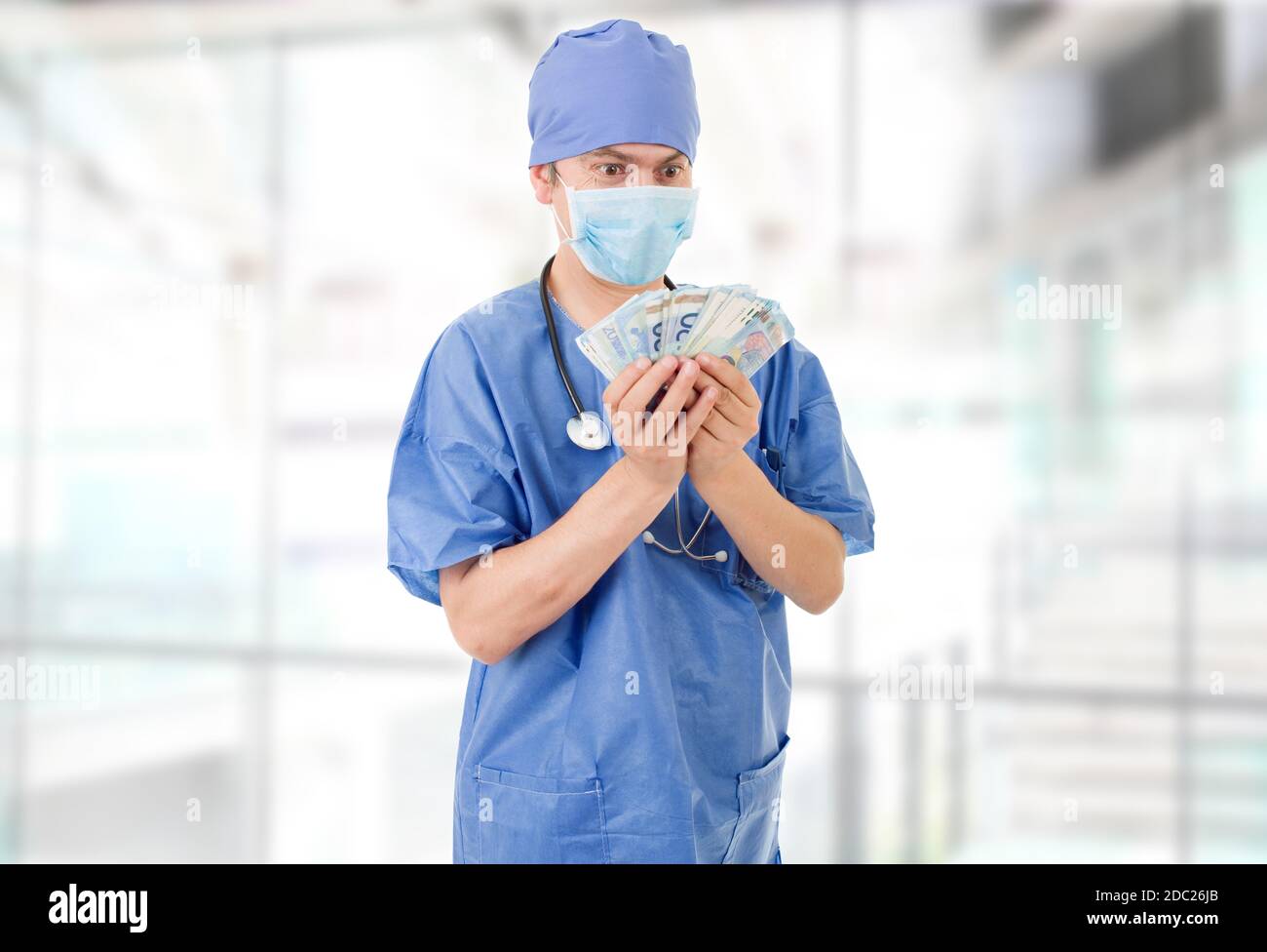 Happy male doctor holding bank notes, at the hospital Stock Photo - Alamy