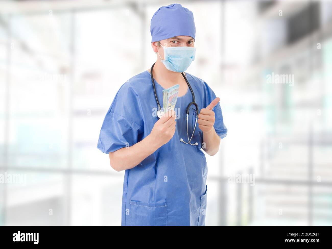 Happy male doctor holding bank notes, at the hospital Stock Photo - Alamy