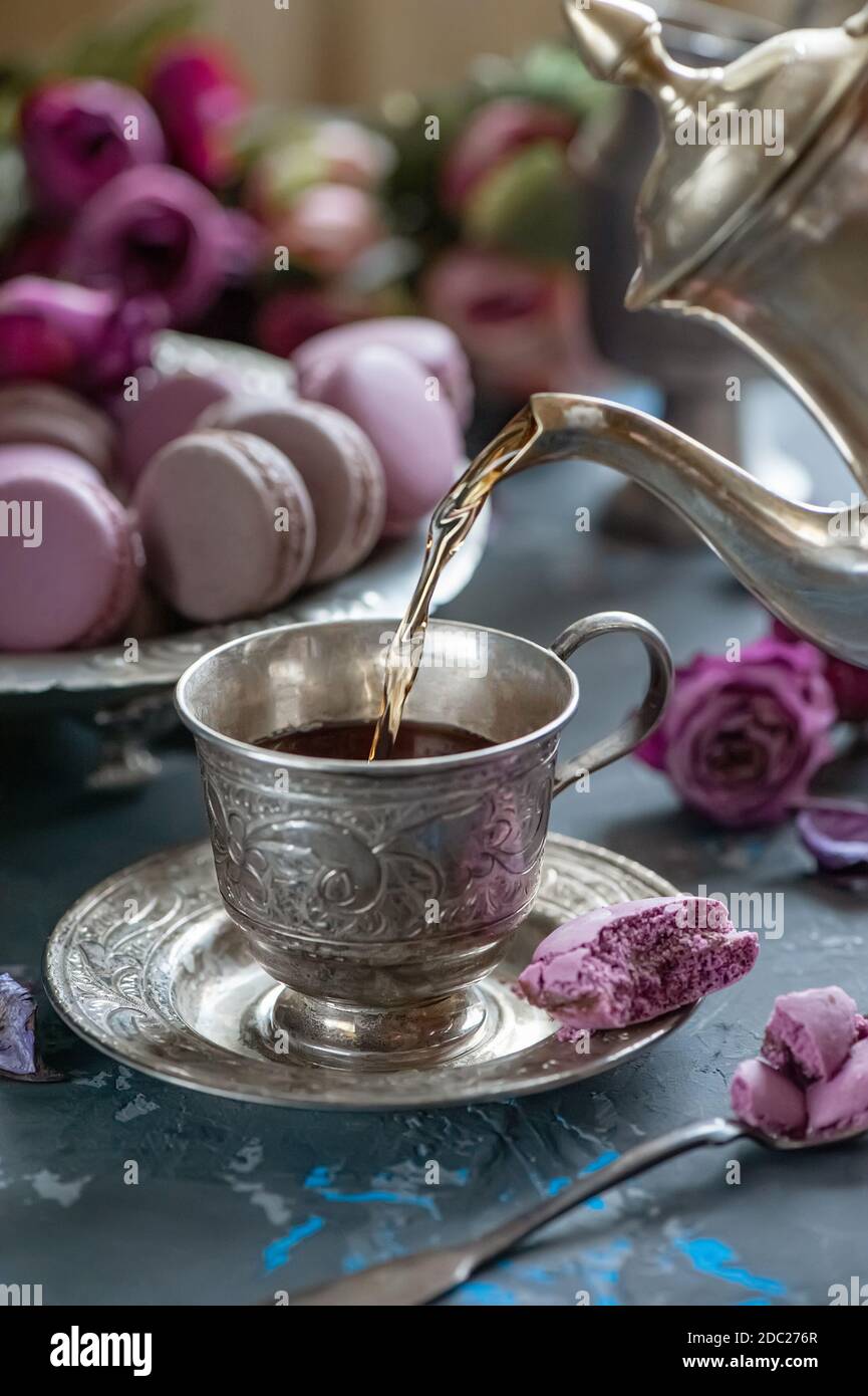 Tea is poured into a beautiful silver antique Cup. Still life of a Cup ...