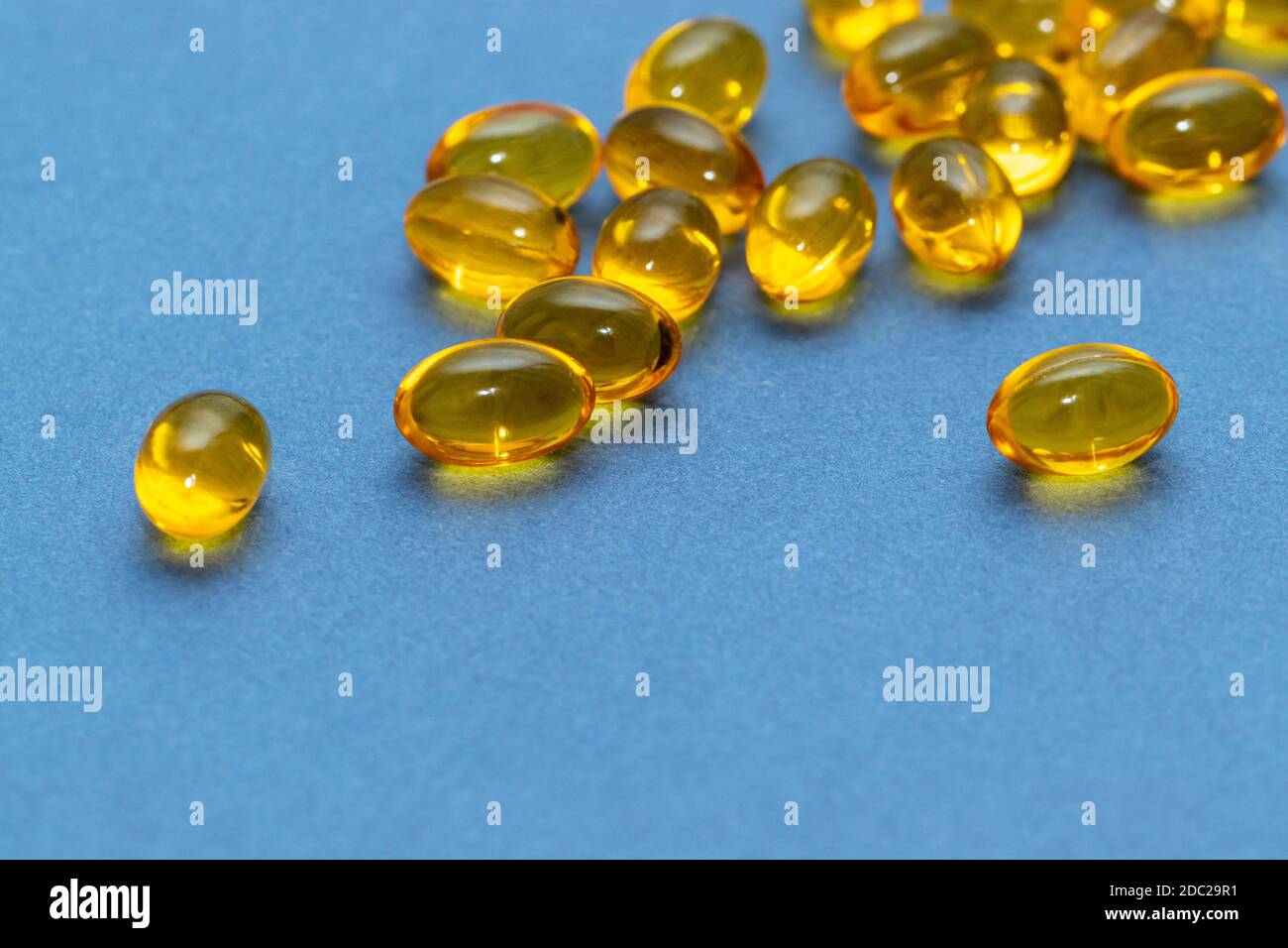 Capsules fish oil yellow sleep blue background Stock Photo - Alamy