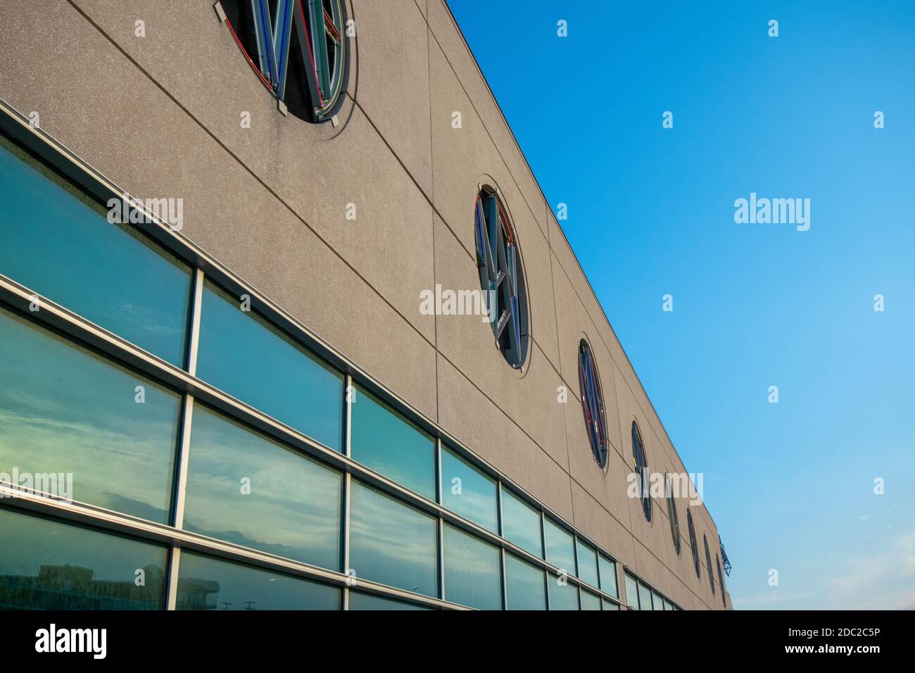 A Tan Building With a Large Window Reflecting the Sunset Sky Stock ...