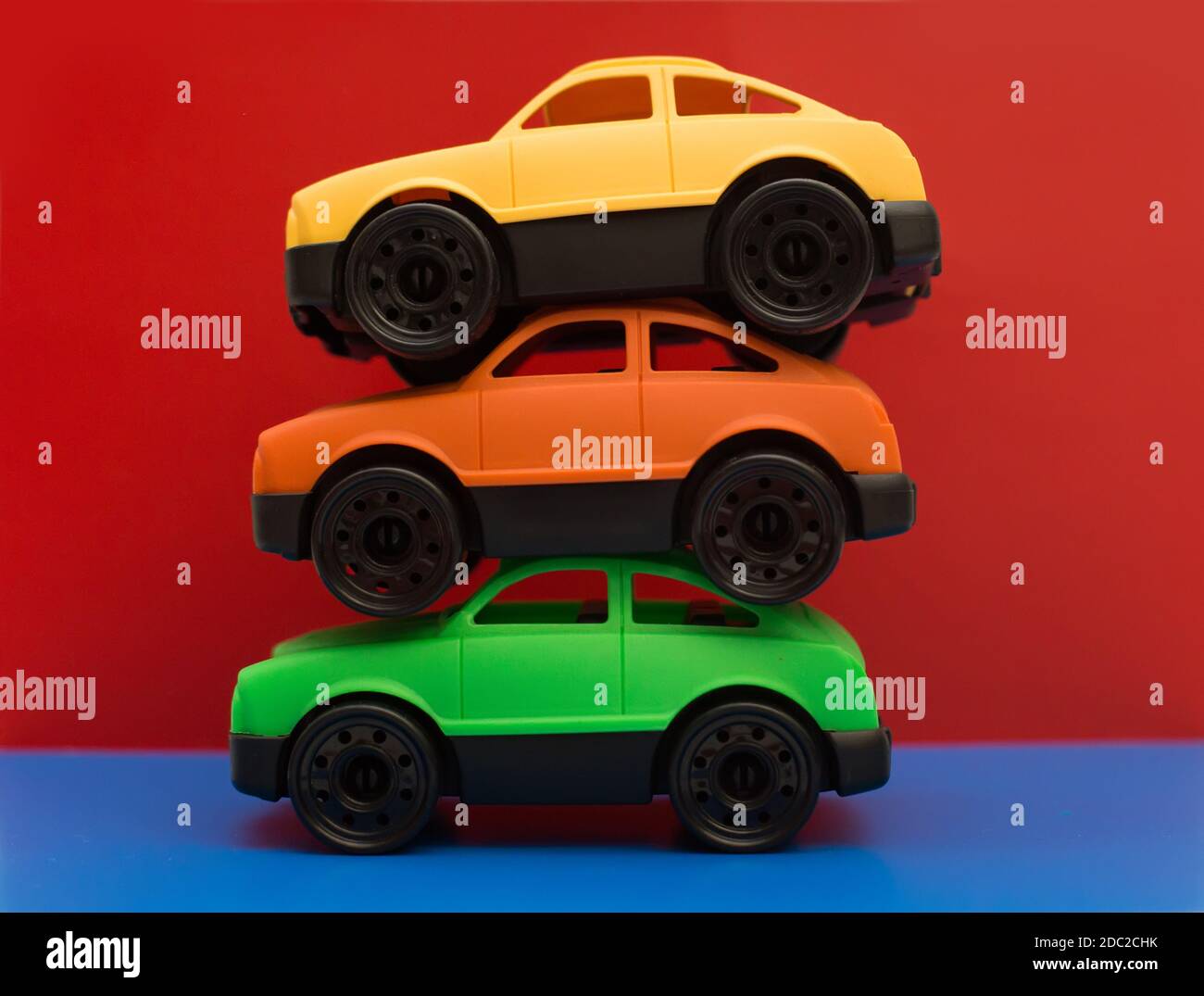 Three toy cars at red and blue background made from recycled recyclable ...