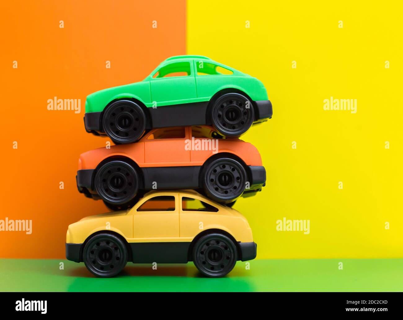 Close up three recycled plastic toy cars at colorful background, saving ...