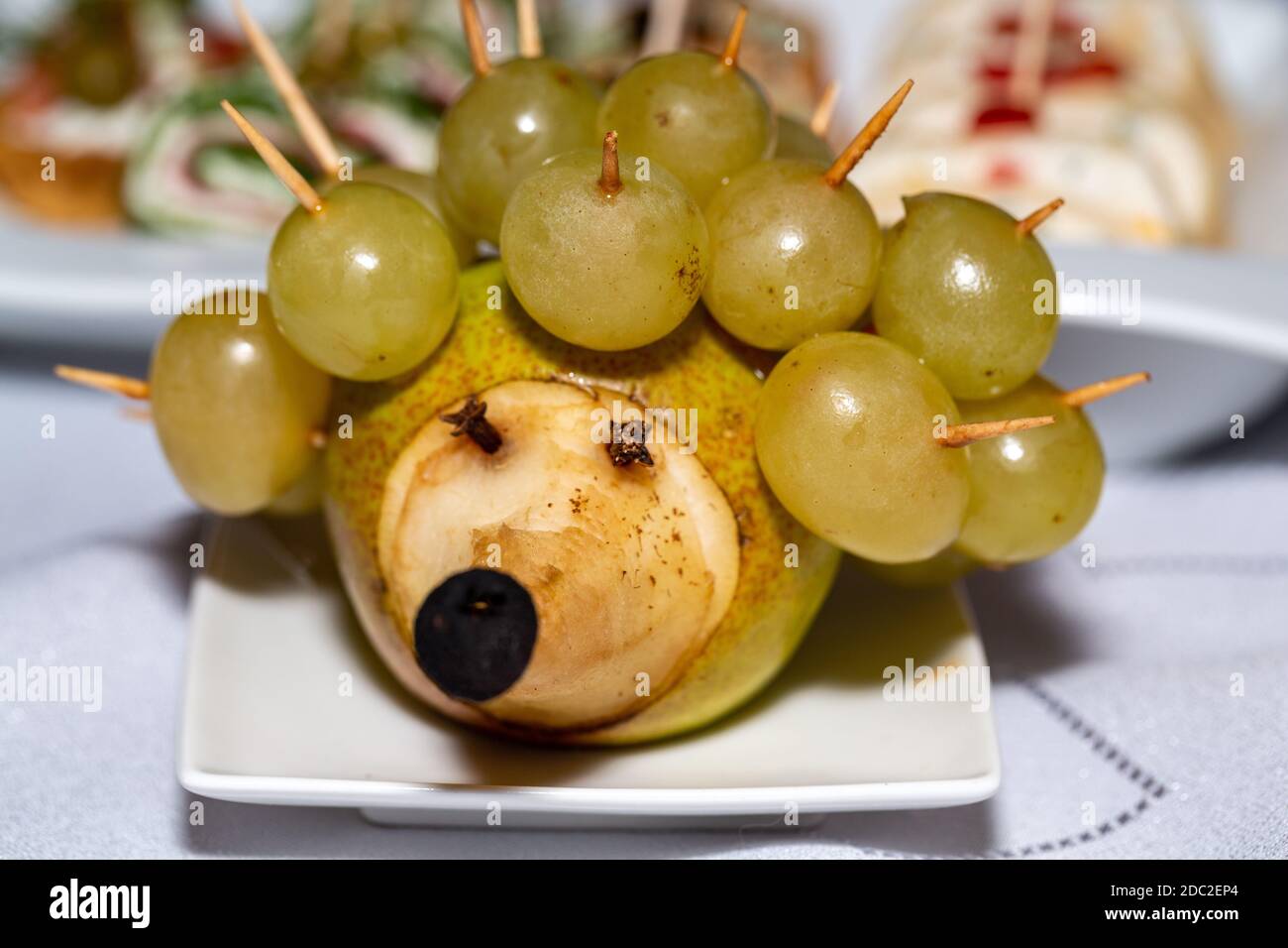 Fruit dessert. Hedgehog made of pears and grapes Stock Photo - Alamy