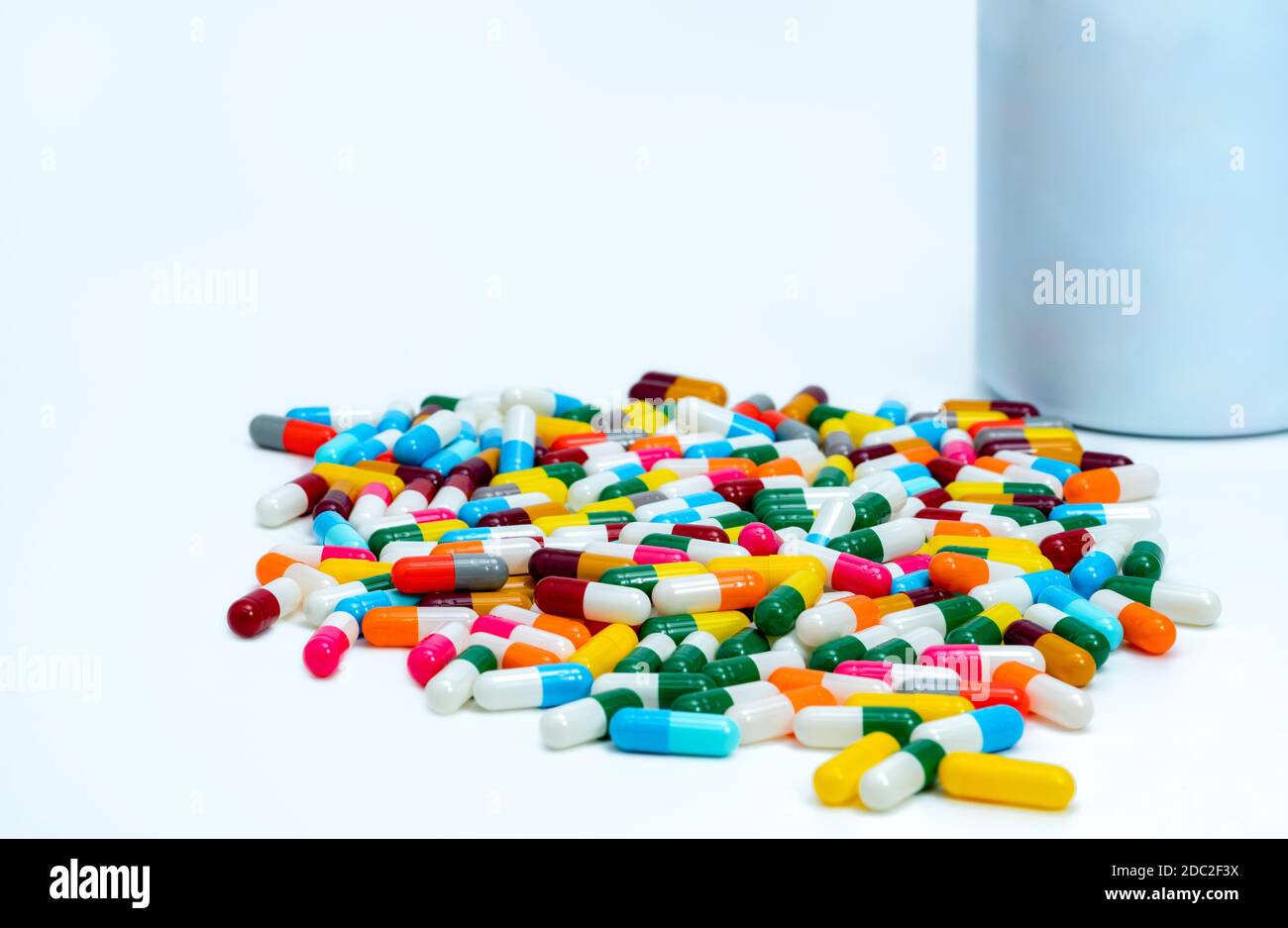 Colorful capsule pills near plastic drug bottle. Multi-colored capsule ...