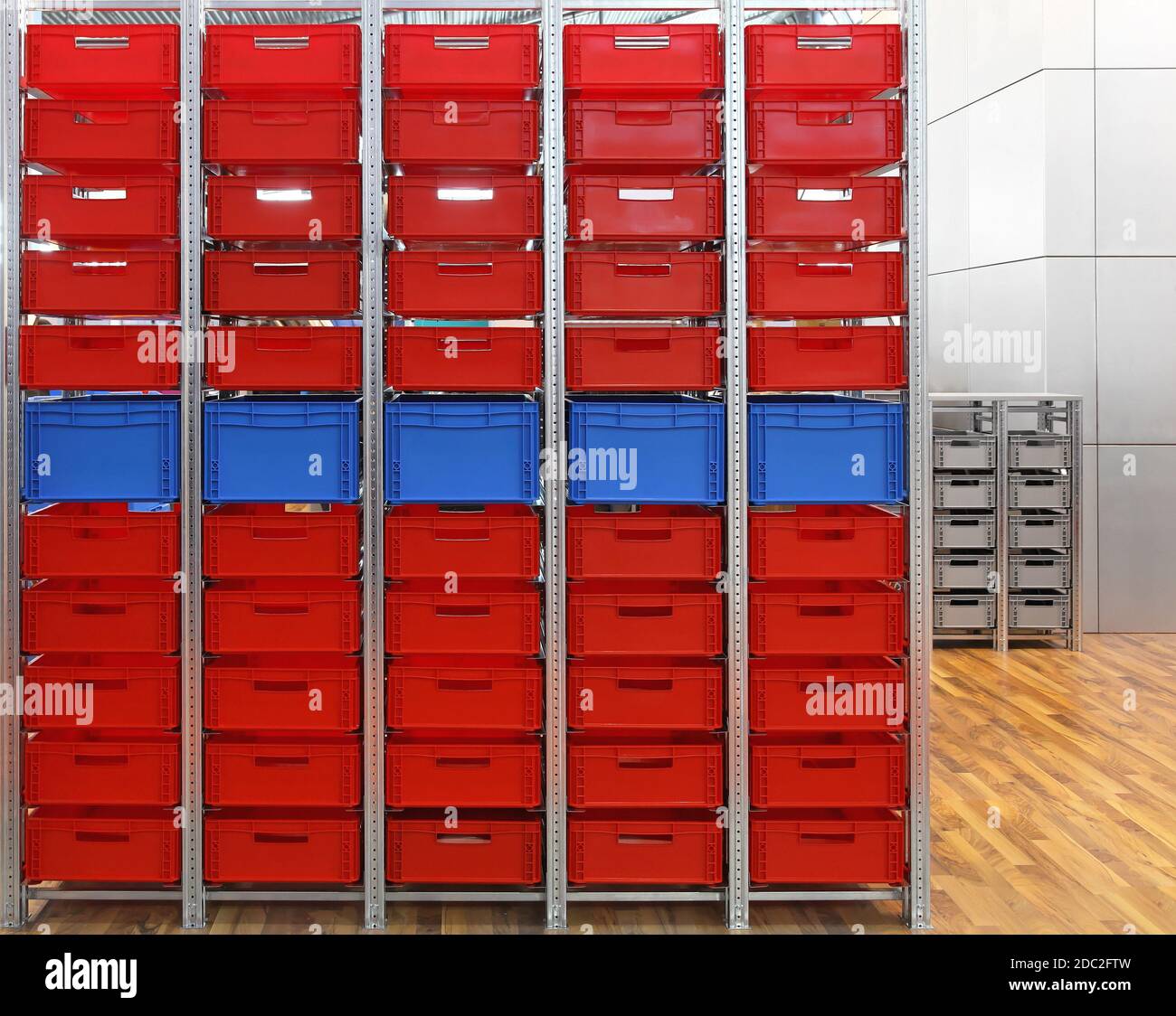 Shelving with red plastic crates in warehouse Stock Photo - Alamy