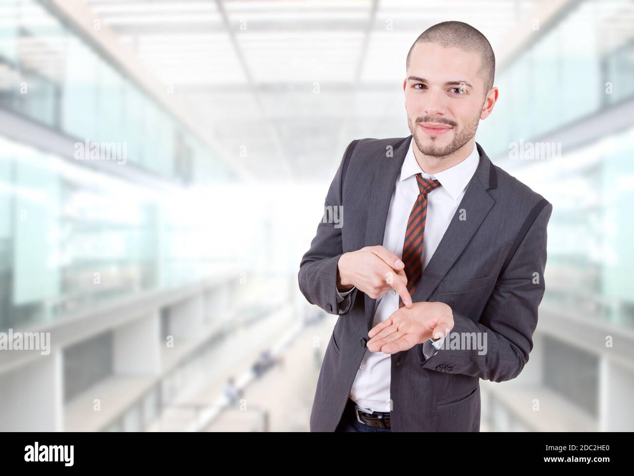 young business man pointing to his hand, at the office Stock Photo - Alamy