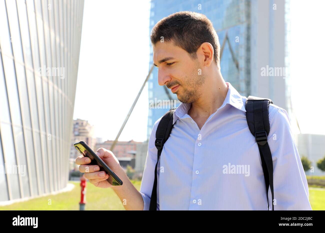 Young business man checking his mobile phone in modern city Stock Photo ...
