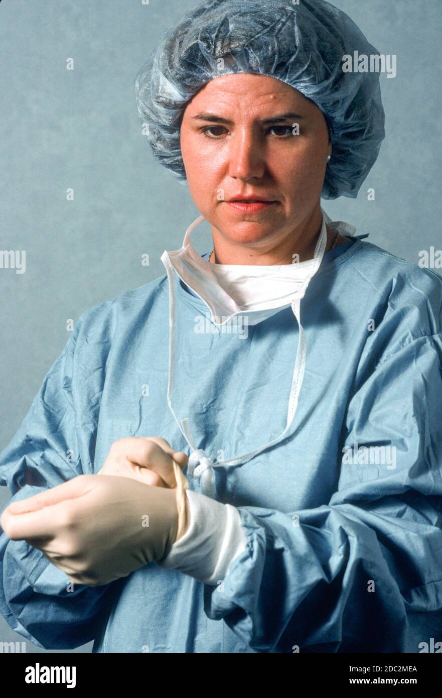 Surgical nurse dons her protective gloves and scrubs, USA 1989 Stock ...
